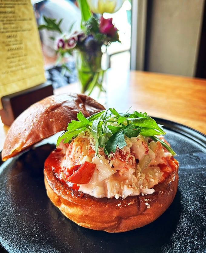 Maine lobster living large on a buttery bun, dressed up with fresh greens like it's heading to a seafood soir&eacute;e.