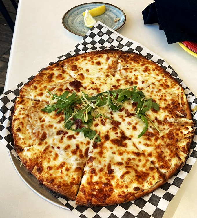 A crispy canvas of melted cheese and fresh arugula - because even a seafood joint knows how to handle the classics.