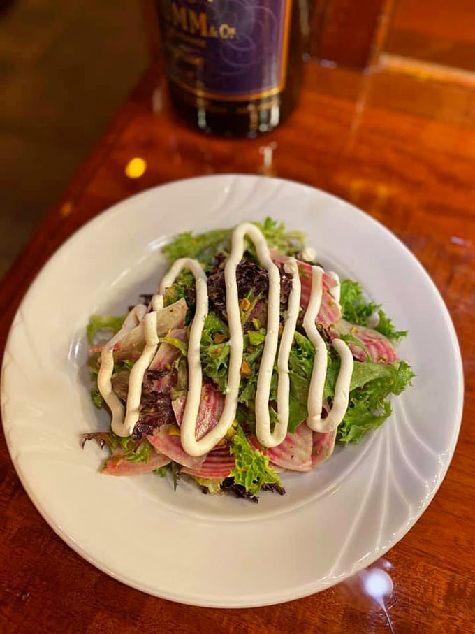 A fresh symphony of greens and radishes, dressed to impress with elegant swoops of house-made dressing.