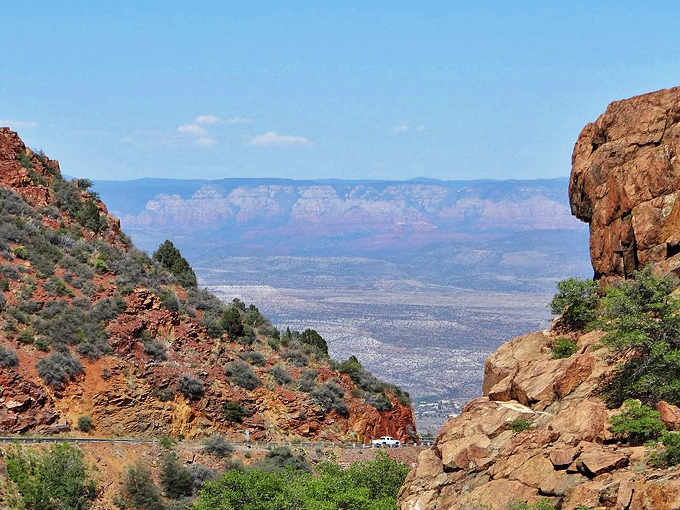 Where civilization meets wilderness: desert scrub and red rock cliffs frame this engineering marvel perfectly.