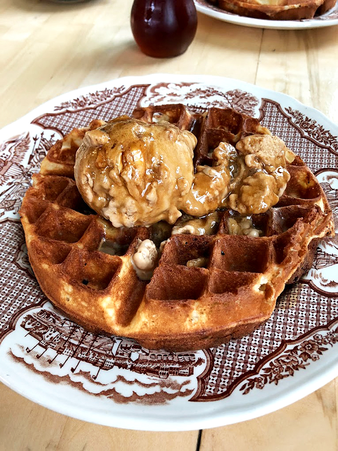 A golden waffle crowned with melting ice cream and syrup - breakfast's answer to "treat yourself."