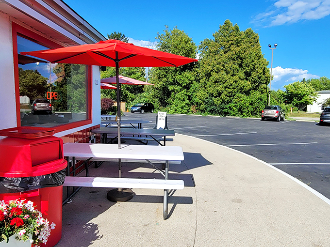 Al fresco dining, drive-in style! These red umbrellas are like beacons of hope for burger lovers seeking sunshine with their shakes.