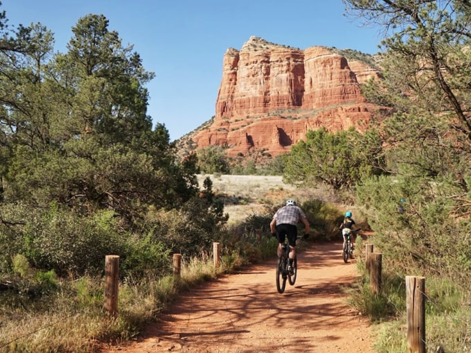 Mountain bikers find their rhythm on this well-maintained trail, with red rock formations providing an epic backdrop.