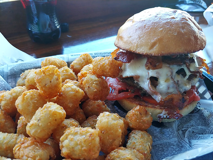 A burger so loaded, it needs its own zip code, accompanied by tater tots that look like little golden pillows of joy.