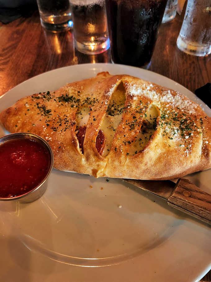This isn't just a calzone - it's a work of art wrapped in perfectly baked dough and dusted with fresh herbs.
