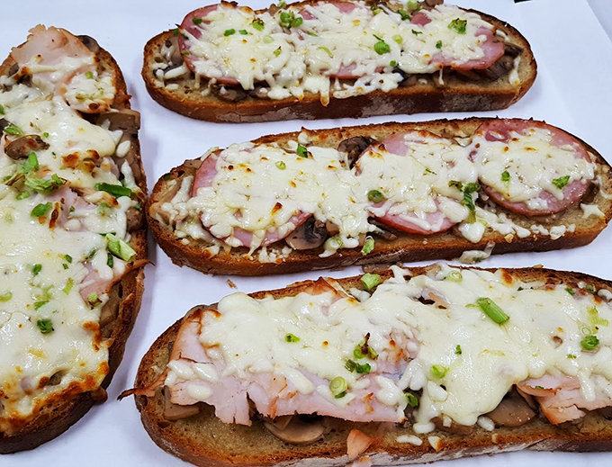 Melted cheese cascades over ham and mushrooms on toasted bread - proof that sometimes the simplest combinations are the most magical.