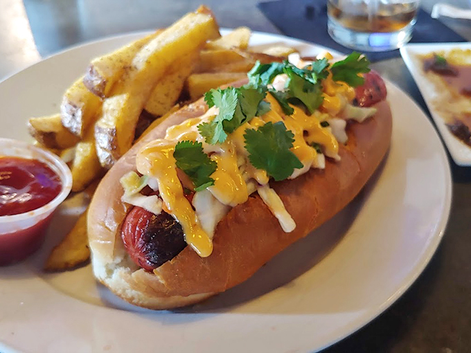 A gourmet hot dog that's dressed to impress, topped with fresh cilantro and a drizzle of sunshine-colored sauce. Photo credit: Joshua Poltrack