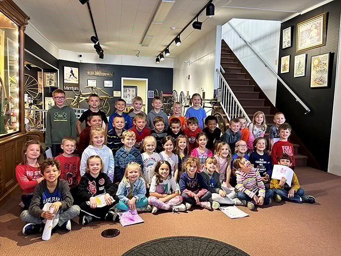 Future Tour de France champions in training? These kids' smiles are brighter than a well-polished bicycle bell at this museum event.