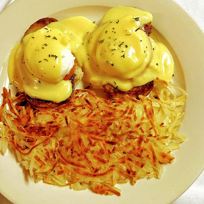 Eggs Benedict perched atop a throne of crispy hash browns &ndash; breakfast royalty at its finest.