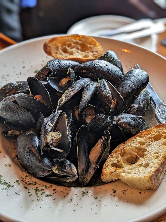 These plump mussels in white wine sauce are like little black-shelled boats sailing in a sea of flavor. Photo credit: Lilian W.