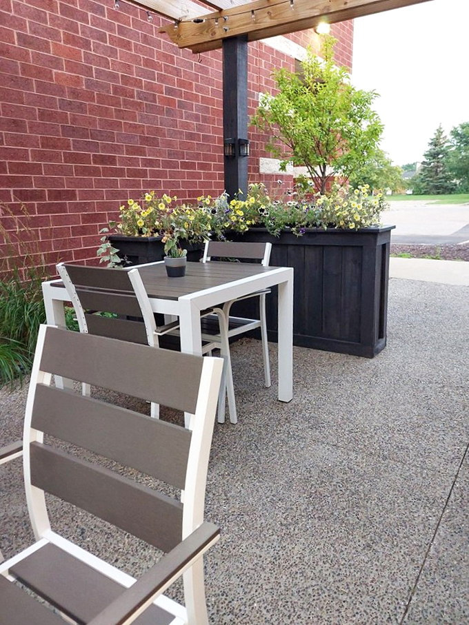 Modern outdoor seating surrounded by flowers&mdash;because fresh air makes everything taste better.