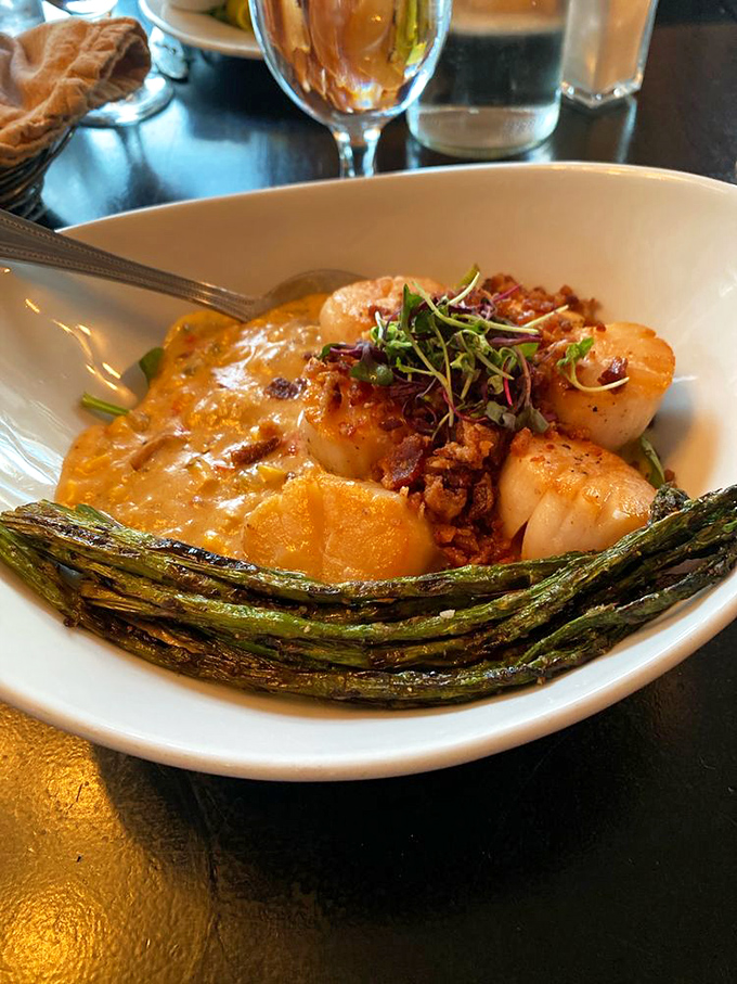 Scallops so perfectly seared, they deserve their own cooking show, nestled alongside grilled asparagus like old friends.