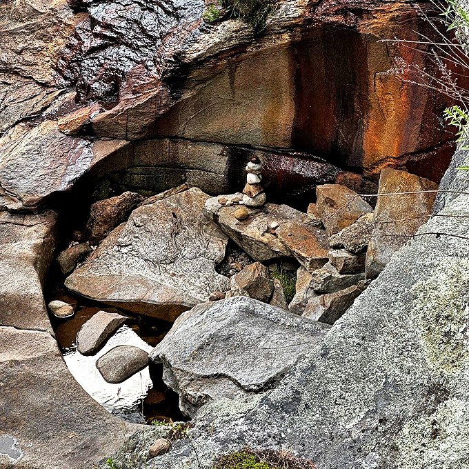Hidden beneath the falls, these rocks create their own miniature sculpture garden, complete with visitor-added cairns.
