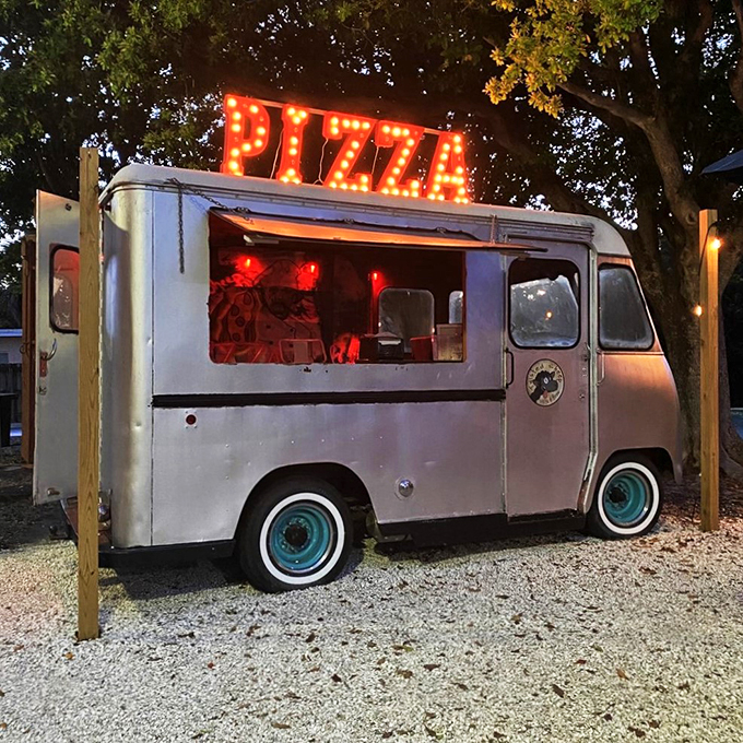 This vintage pizza truck glows with retro charm, adding a touch of nostalgia to evening dining under the stars.