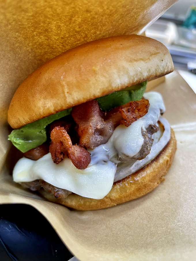 Bacon and cheese unite on this burger like old friends at a backyard barbecue, creating pure handheld happiness. Photo credit: Backwoods Burger Shack