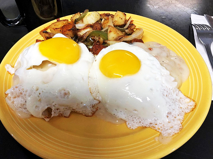 Two sunny eggs perched atop their throne of English muffins, draped in hollandaise like royalty wearing their finest gold robes.
