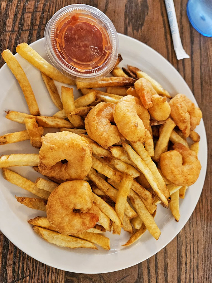 These plump fried shrimp aren't just dinner - they're little soldiers of satisfaction, guarding their territory of crispy fries.