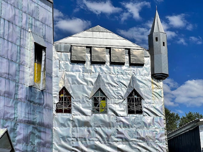 The castle's geometric windows catch sunlight like stained glass, proving recycled materials can create medieval magic.