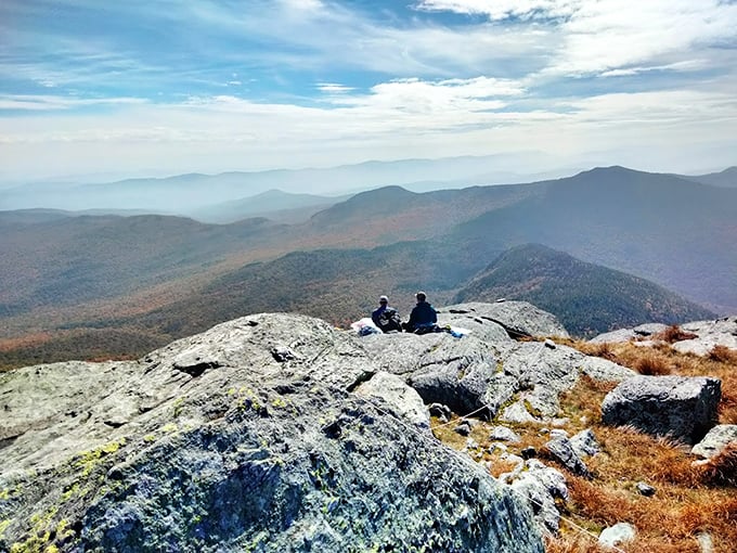 The best seat in the house, courtesy of Mother Nature. These hikers look like they've found the world's comfiest rock couch with a view to match.