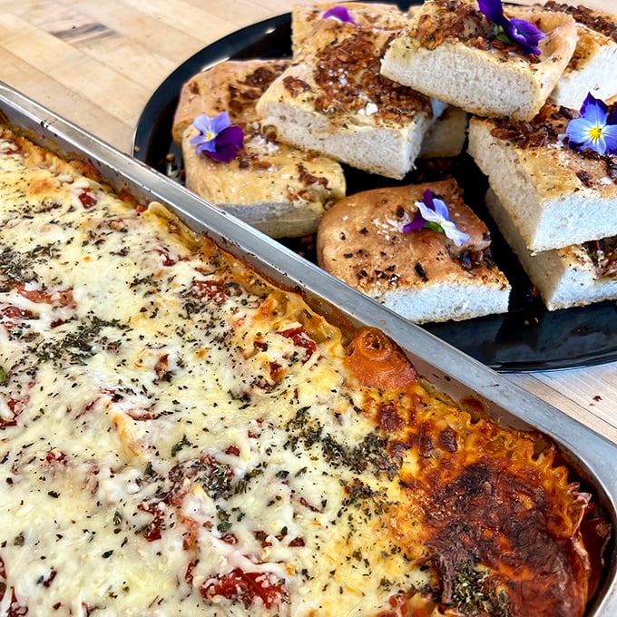 Comfort food gets dressed up: lasagna and garlic bread adorned with edible flowers make dinner feel like an occasion.