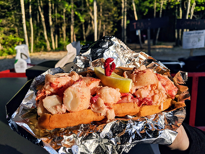 The king of the sea, dethroned and delicious! This lobster roll is so packed, it's practically doing bicep curls in its tin foil throne.