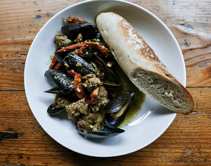 The king of the sea meets the king of shellfish - Maine lobster and clams sharing a plate in perfect harmony.