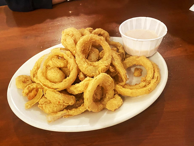 Golden-brown onion rings that are basically edible halos, served with a side of heavenly dipping sauce.