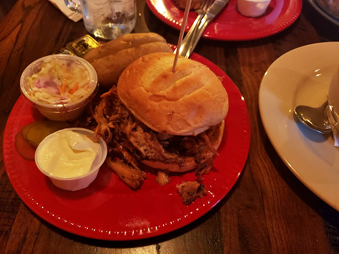 A mountain of tender pulled pork on a fresh bun - proof that this barn takes its BBQ as seriously as its location.