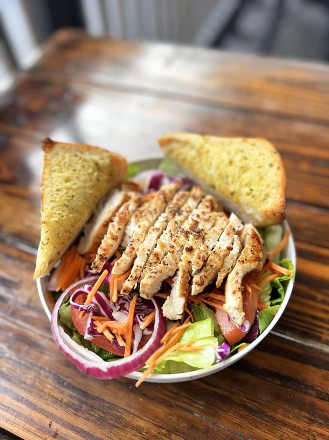 Grilled chicken perches atop a rainbow of fresh vegetables, proving seafood isn't the only star here.