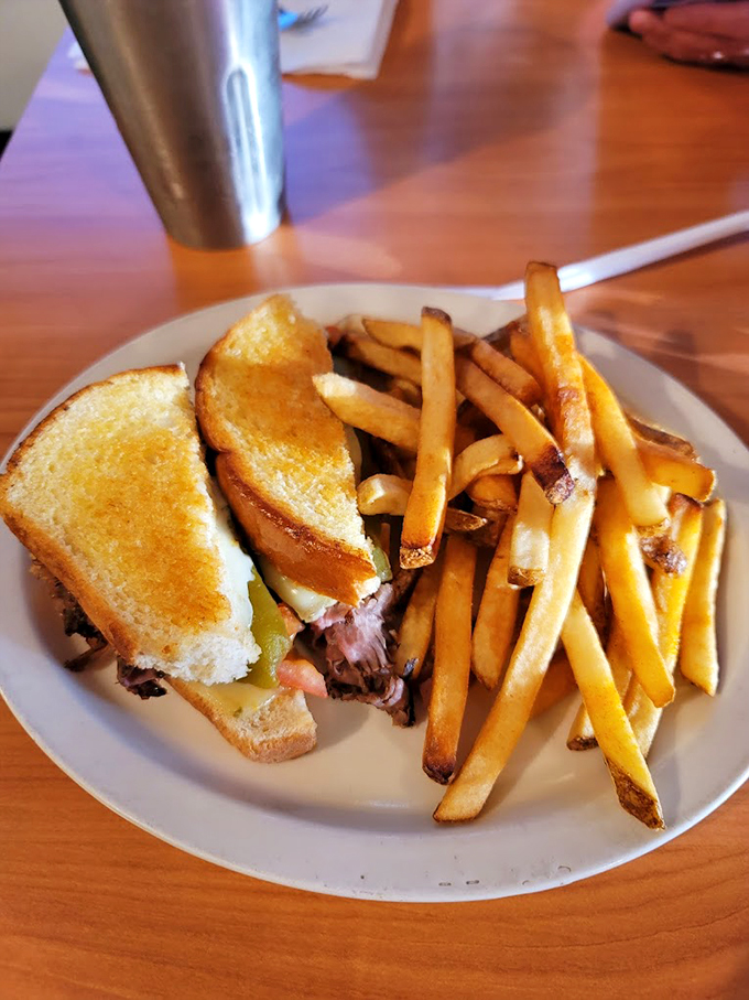 Golden-grilled bread hugs tender meat while crispy fries stand at attention - the classic lunch done right.