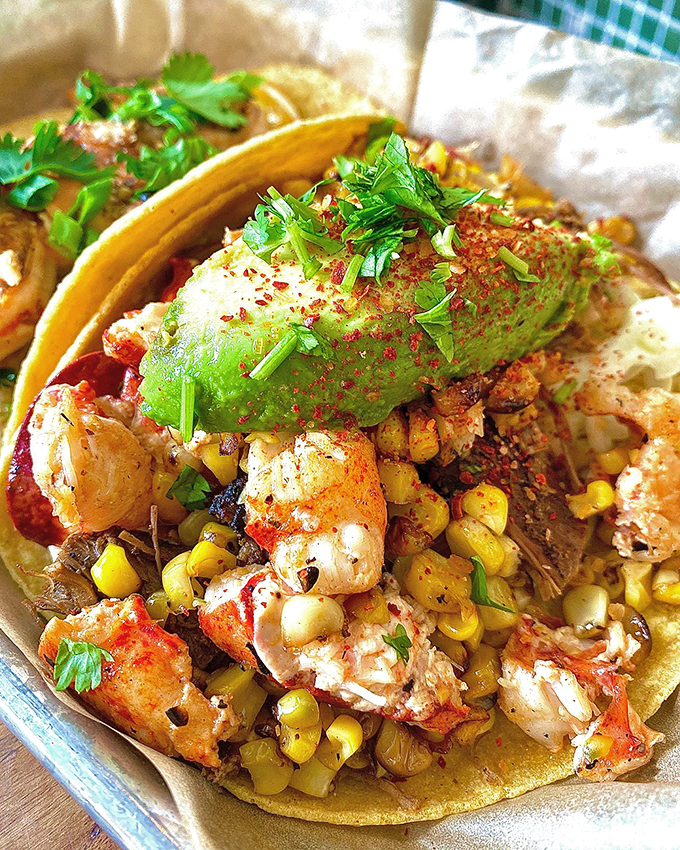 Maine meets Mexico in perfect harmony: fresh lobster, grilled corn, and avocado nestled in a warm tortilla.