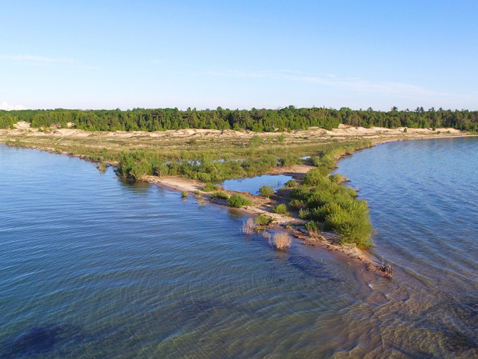 Island in the stream, that is what we are. Fisherman's Island floats like a green jewel in Lake Michigan's azure embrace.
