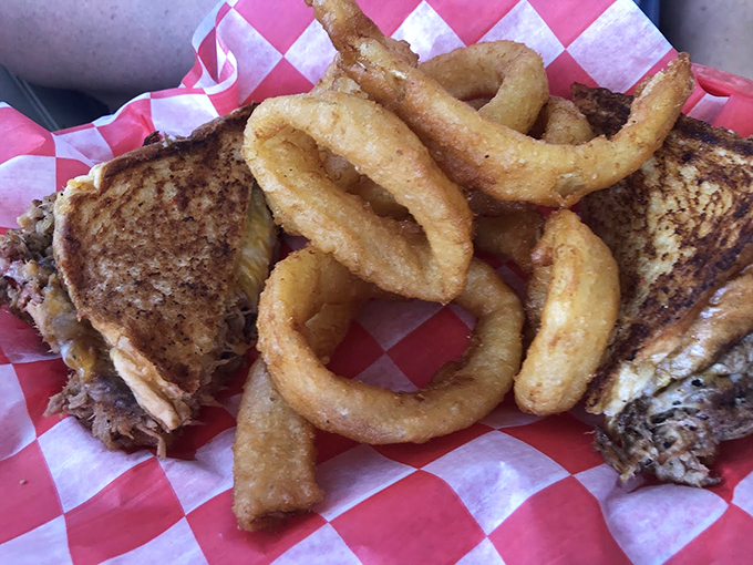 Pulled pork perfection! Nestled next to crispy onion rings, it's a Southern symphony on a red-checkered stage.
