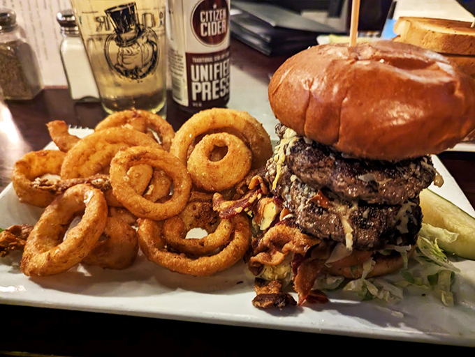 A burger that requires a game plan to eat, flanked by onion rings that could double as delicious bracelets.