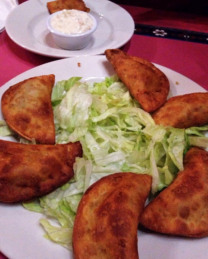 Golden-fried empanadas form a crispy crown around fresh lettuce - a simple but satisfying starter that sets the tone.