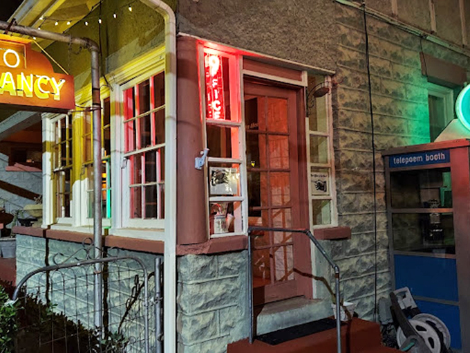 Night transforms the entrance into an enchanting scene where vintage neon meets modern-day whimsy.