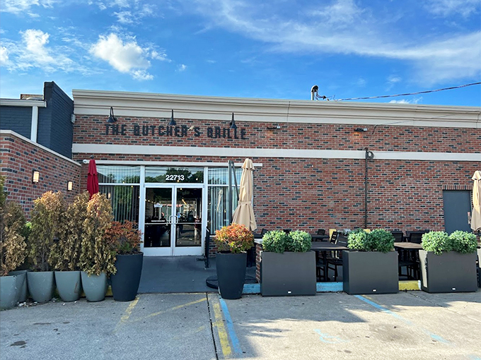 Planters full of greenery frame the entrance, making this brick building feel like a hidden garden of culinary delights. 