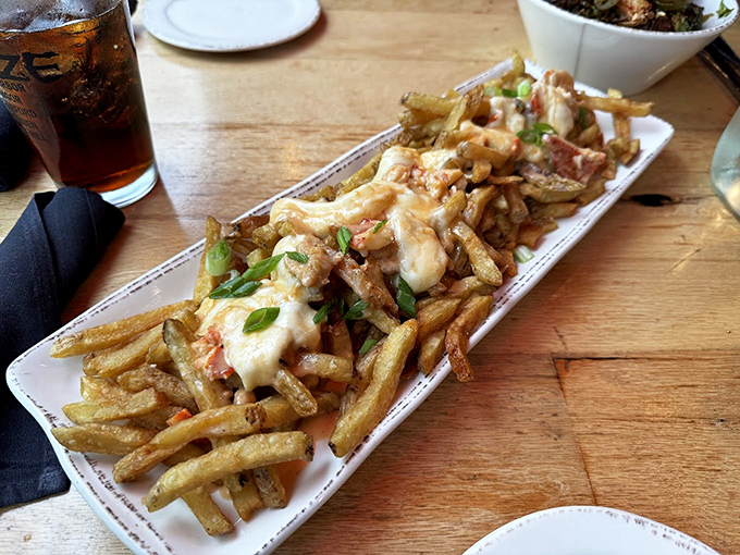 Loaded fries that tell a story of comfort food elevated to art form, topped with melty cheese and fresh herbs.
