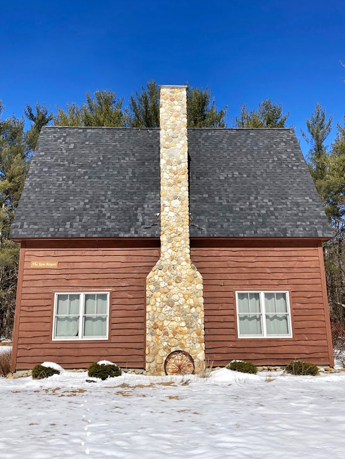 The Stone House stands as a charming sentinel in the woods, its chimney reaching skyward like a friendly hello.