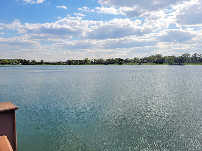 The lake stretches out like nature's mirror, reflecting clouds that seem to dance across its surface.