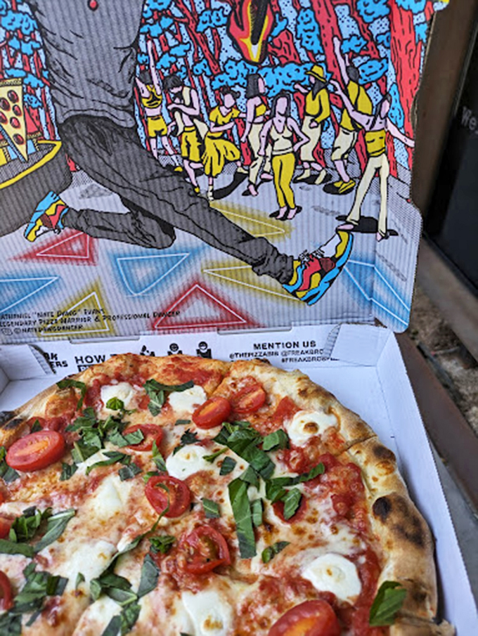 Fresh basil, ripe tomatoes, and melted mozzarella make this pizza a work of art worthy of its artistic surroundings.