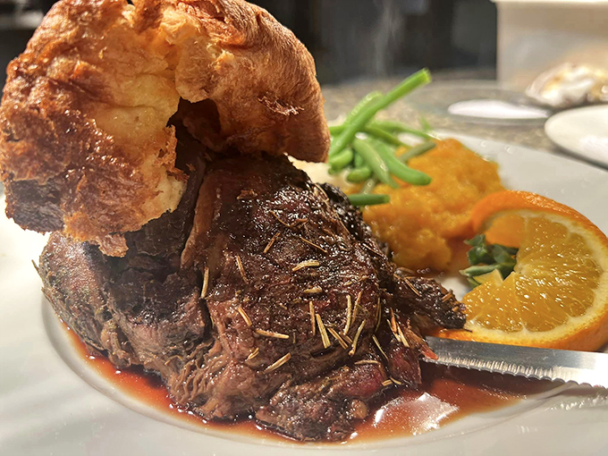 A towering Yorkshire pudding crowns this prime rib like a royal hat, making every bite a regal experience.