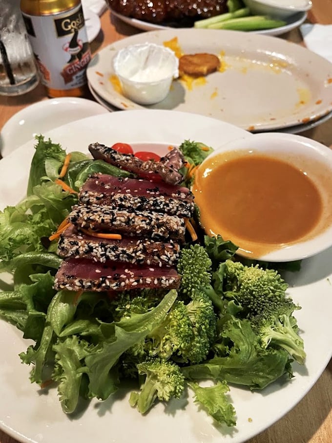 Sesame-crusted tuna fans across fresh greens like a deck of cards, bringing steakhouse elegance to pub fare.