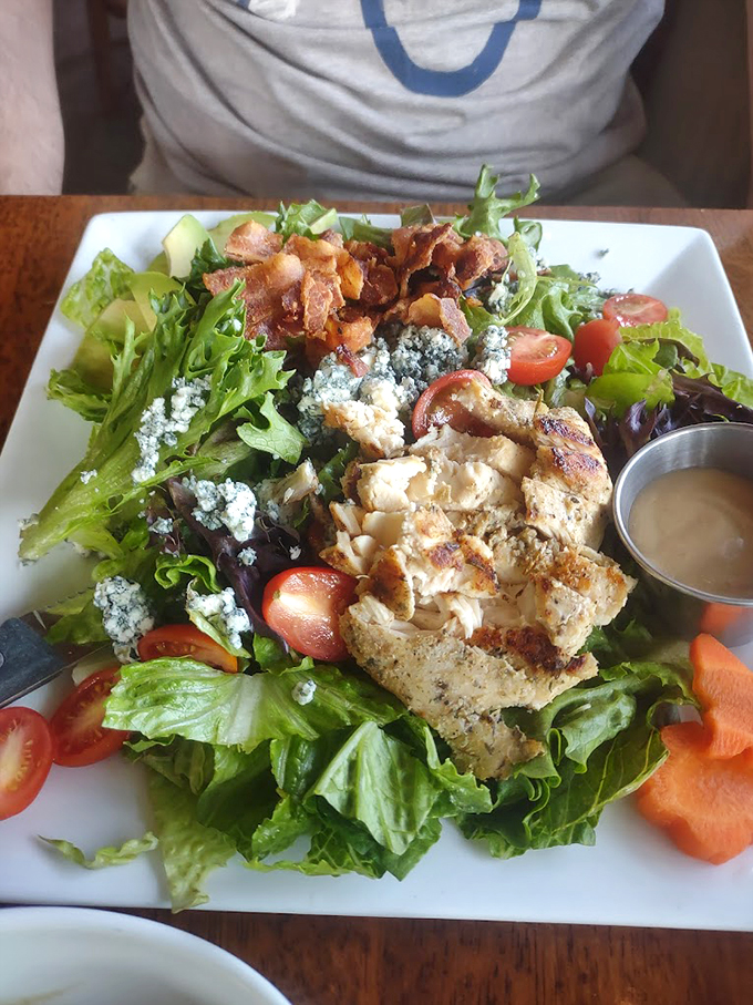 A hearty salad topped with grilled chicken, crispy bacon, and blue cheese proves pub food can be both healthy and satisfying. Photo credit: Brianna Roberge