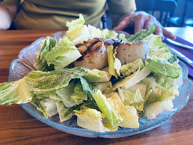 A Caesar salad crowned with perfectly seared scallops &ndash; where land meets sea in perfect harmony. Photo credit: X M.