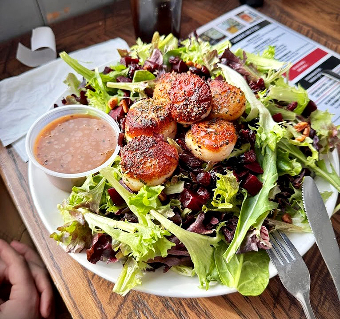 Proof that seafood can do fancy - seared scallops crown this garden of greens like jewels on nature's throne.