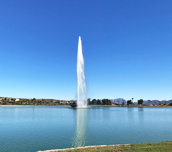 The fountain's graceful arc creates a mesmerizing reflection, doubling the drama against the desert sky.