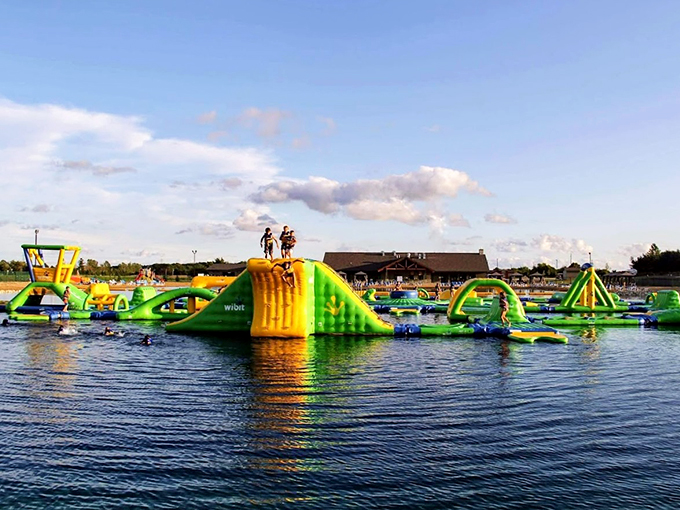 A floating playground of colorful inflatables creates an aquatic obstacle course that's basically American Ninja Warrior meets pool party.