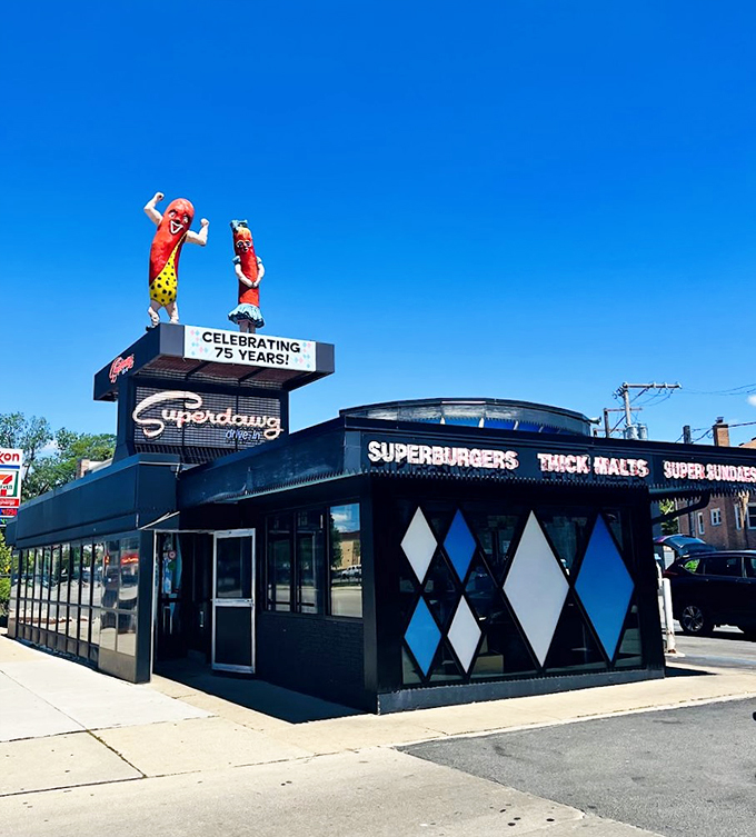 Guardians of the grill! These towering wiener warriors stand watch over Chicago's tastiest time machine. Superdawg's neon-lit nostalgia serves up a bite of the 1950s.