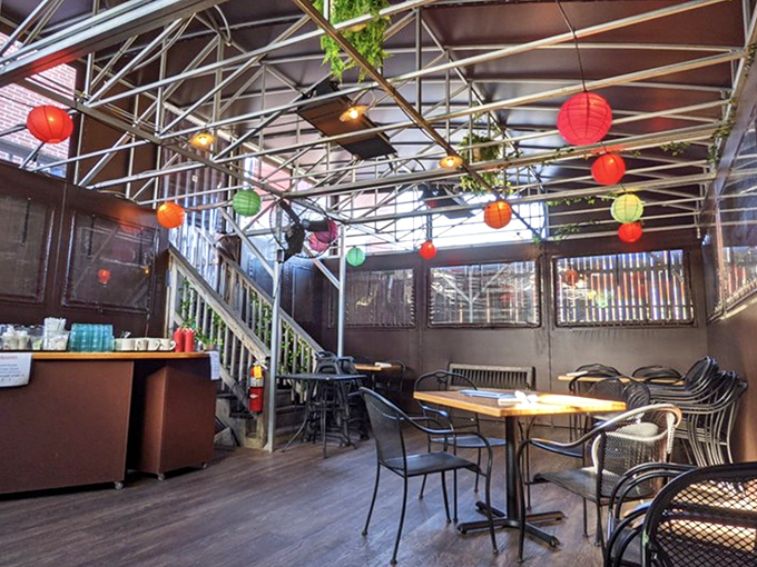 Colorful paper lanterns dance overhead in the covered patio, creating an intimate garden party vibe that makes every meal feel special.
